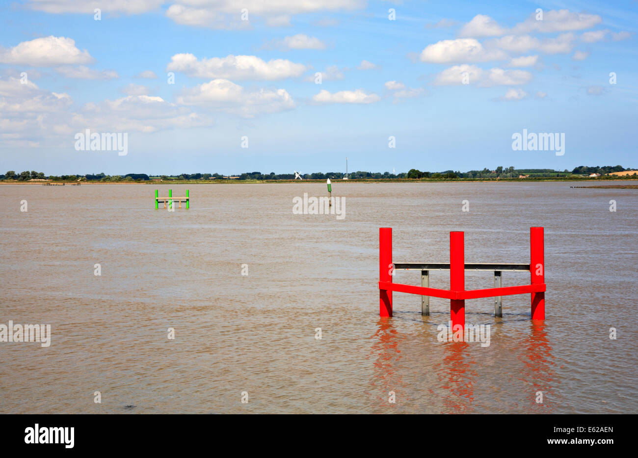 A view of Breydon Water with channel markers and mooring posts near ...