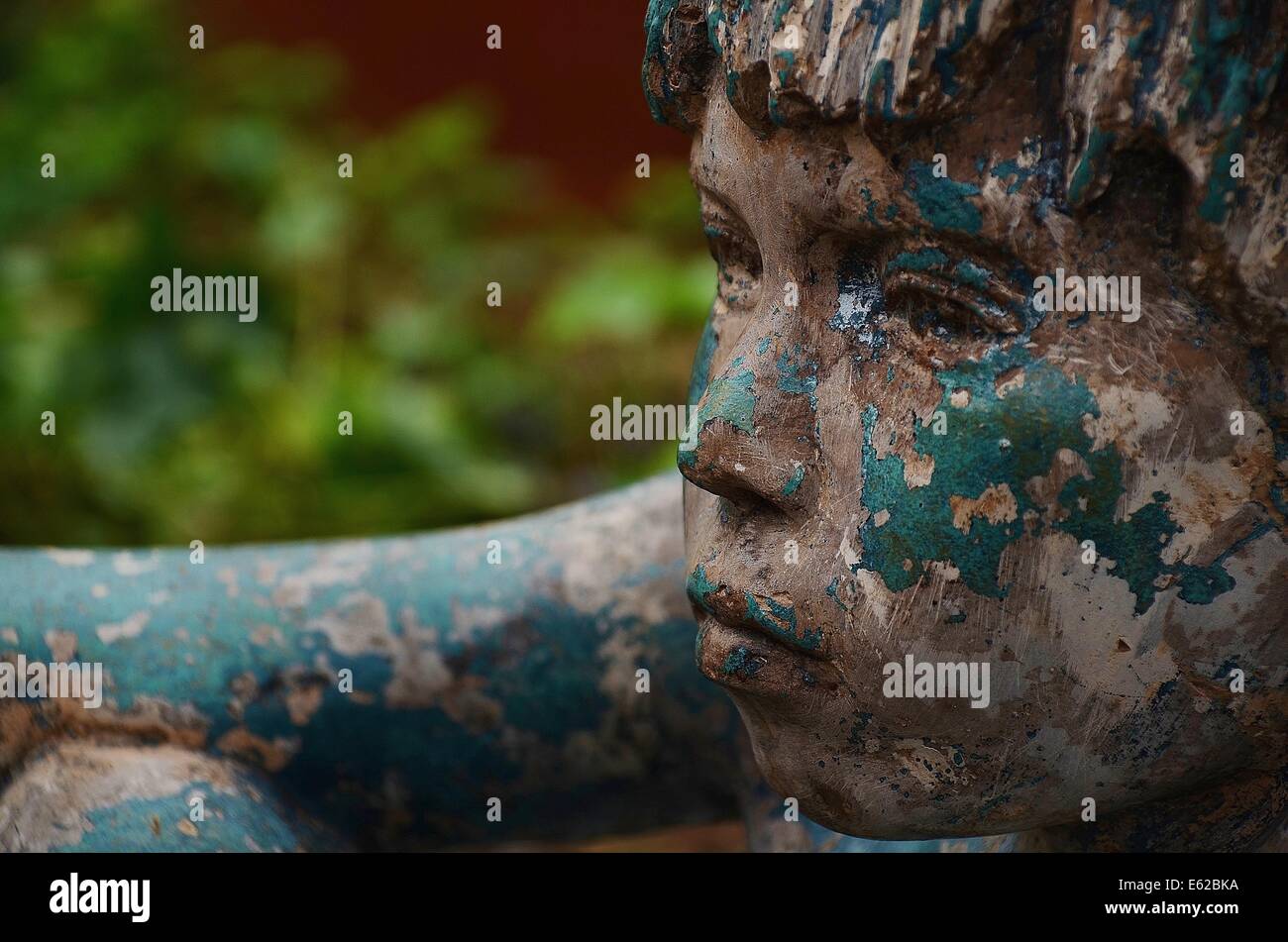 A bronze statue depicting the profile of a young boy. The figure ...