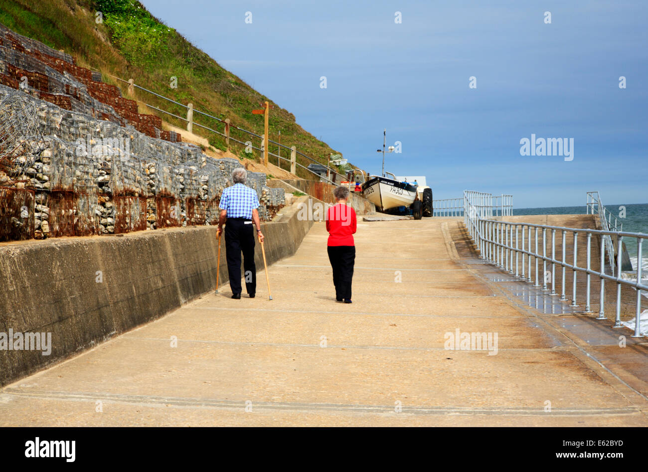 An elderly couple walking on the promenade at Overstrand, Norfolk ...