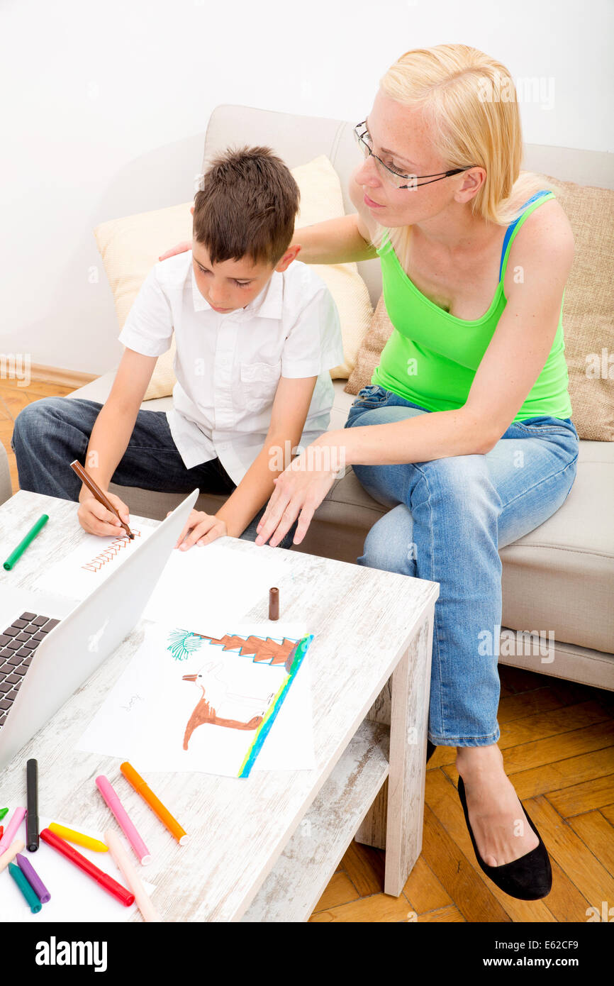 Kids drawing with happy parents on the couch Stock Photo - Alamy