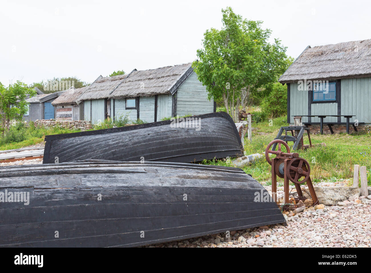 Old cottage with boats on the beach Stock Photo - Alamy