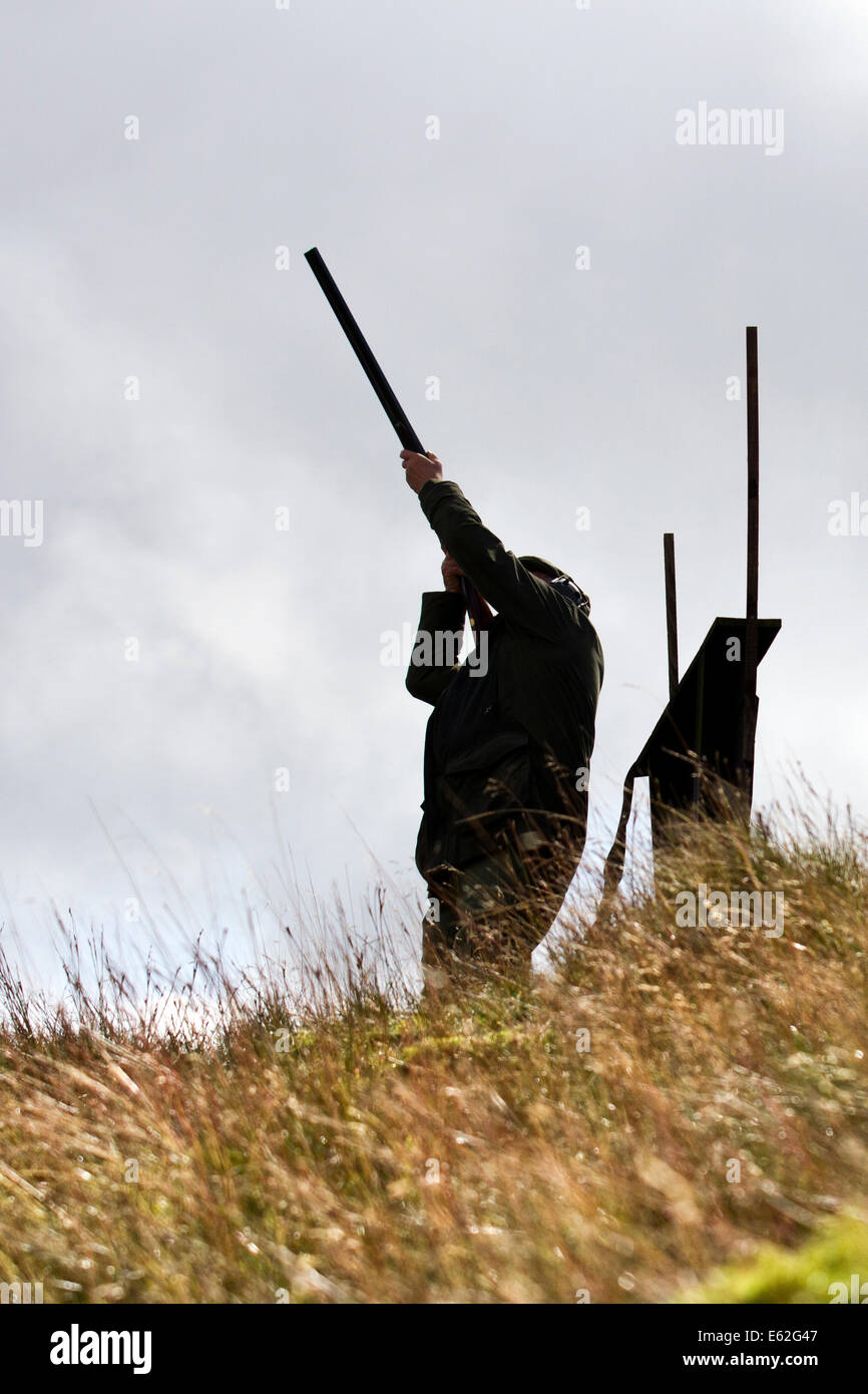 Silhouetted figures holding shotgun in Coverdale, North Yorkshire Dales ...