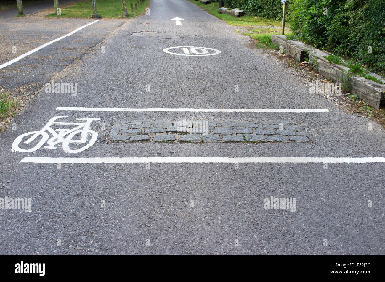 Sleeping policeman speed hump in road with cycle path gap Stock Photo ...