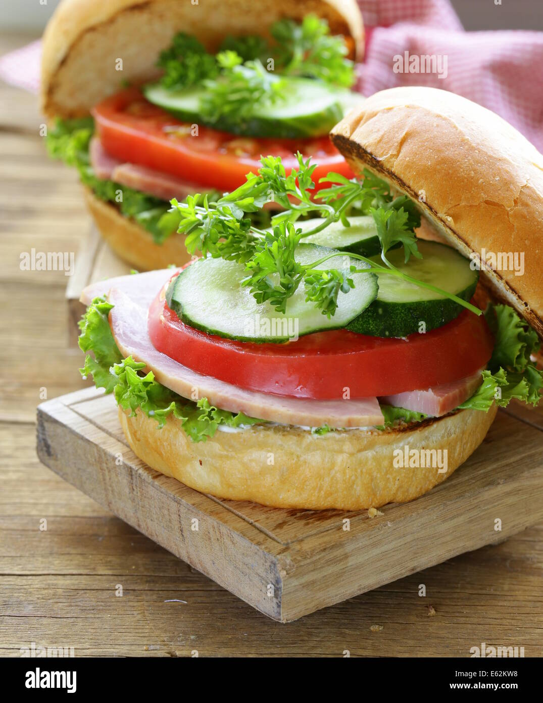 snack burger with fresh vegetables and ham on a wooden board Stock ...