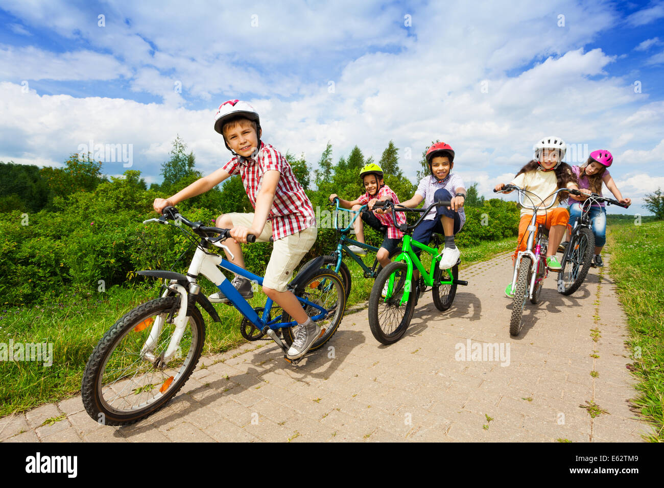 Kids in helmets riding bikes together Stock Photo - Alamy
