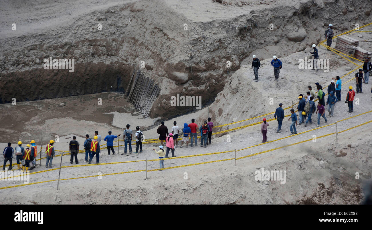 Quito, Ecuador. 12th Aug, 2014. People watch a landslide caused by an ...