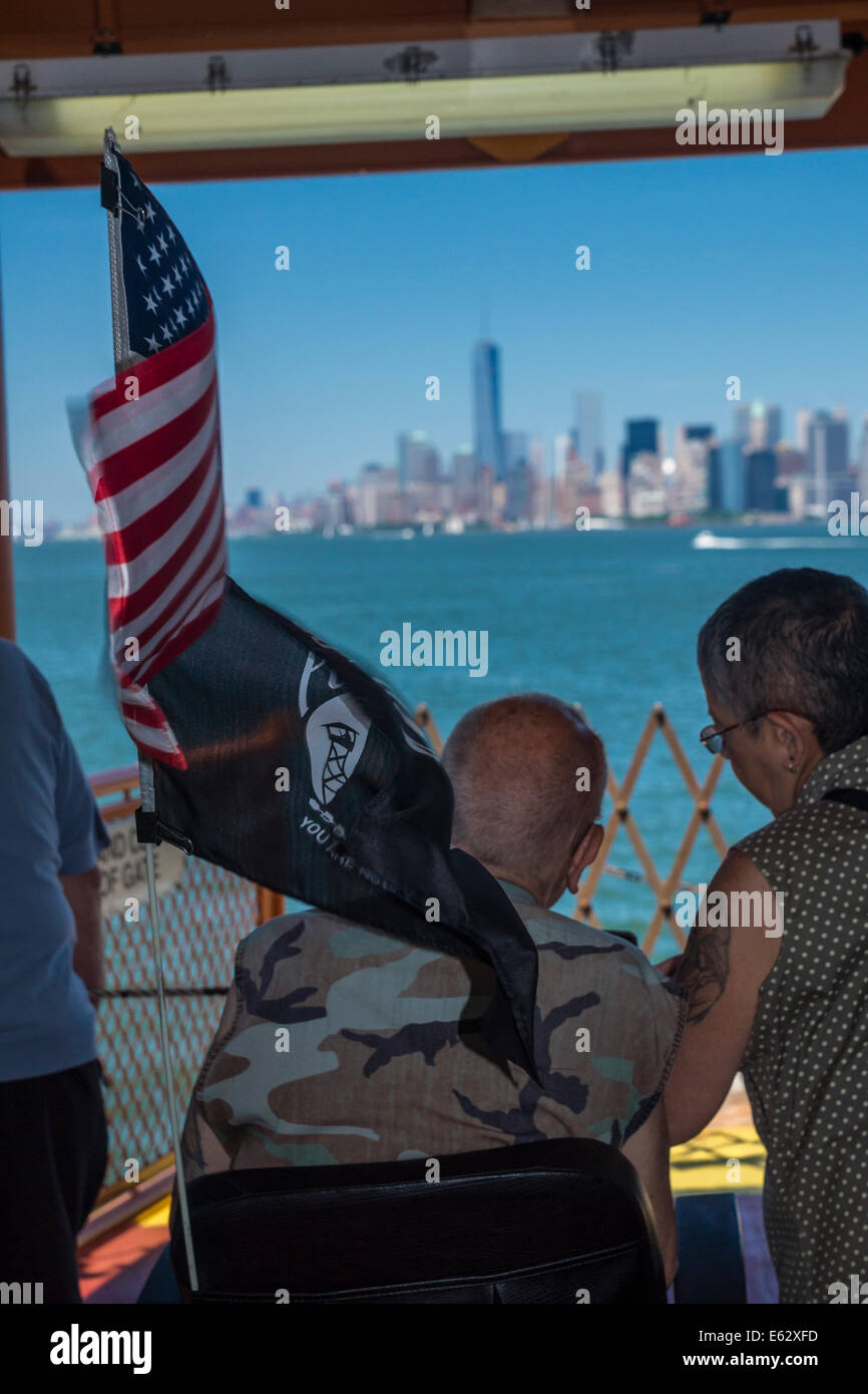 A disabled army veteran, with a US flag and a flag for POW and MIA ...