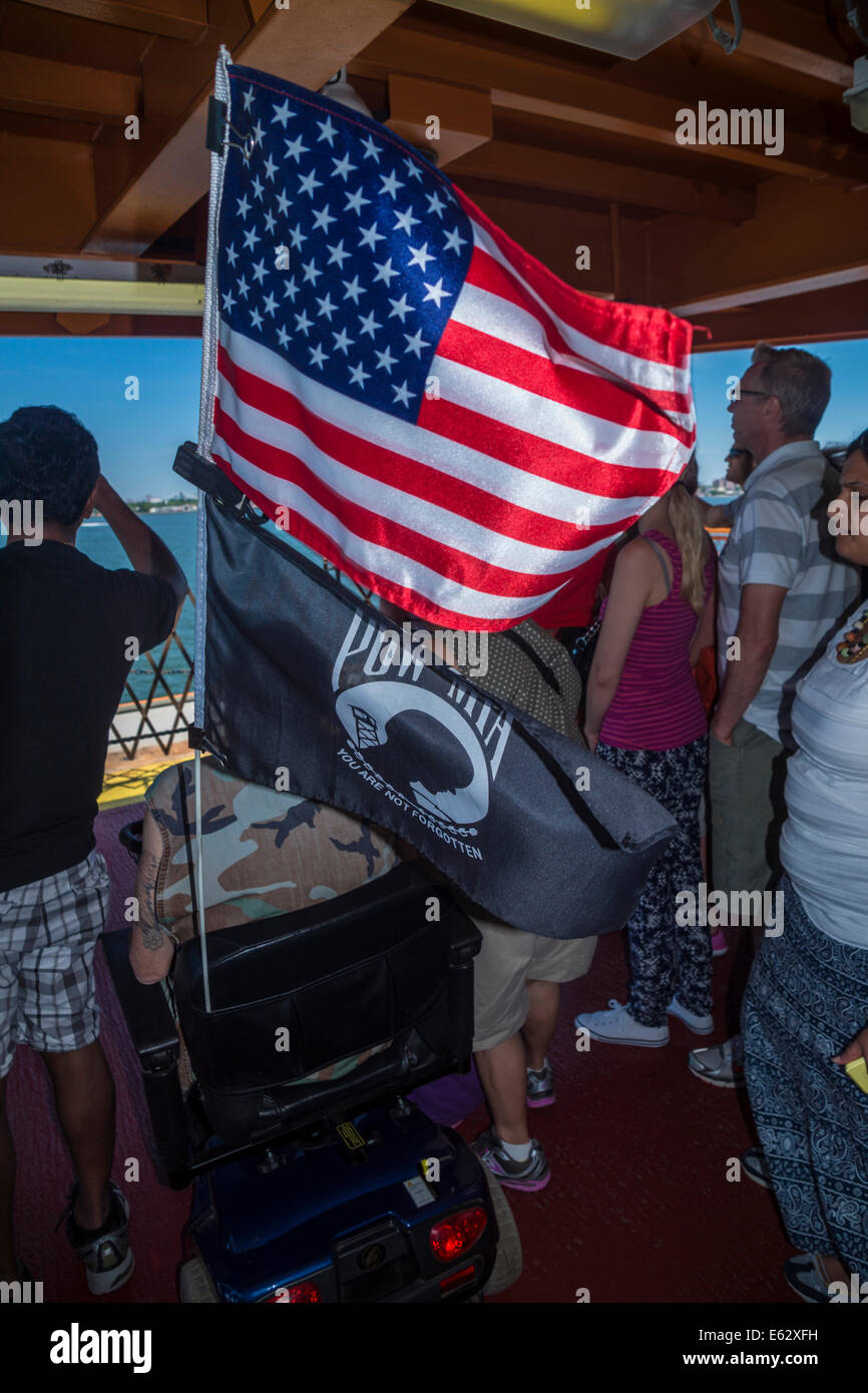 A disabled army veteran, with a US flag and a flag for POW and MIA ...