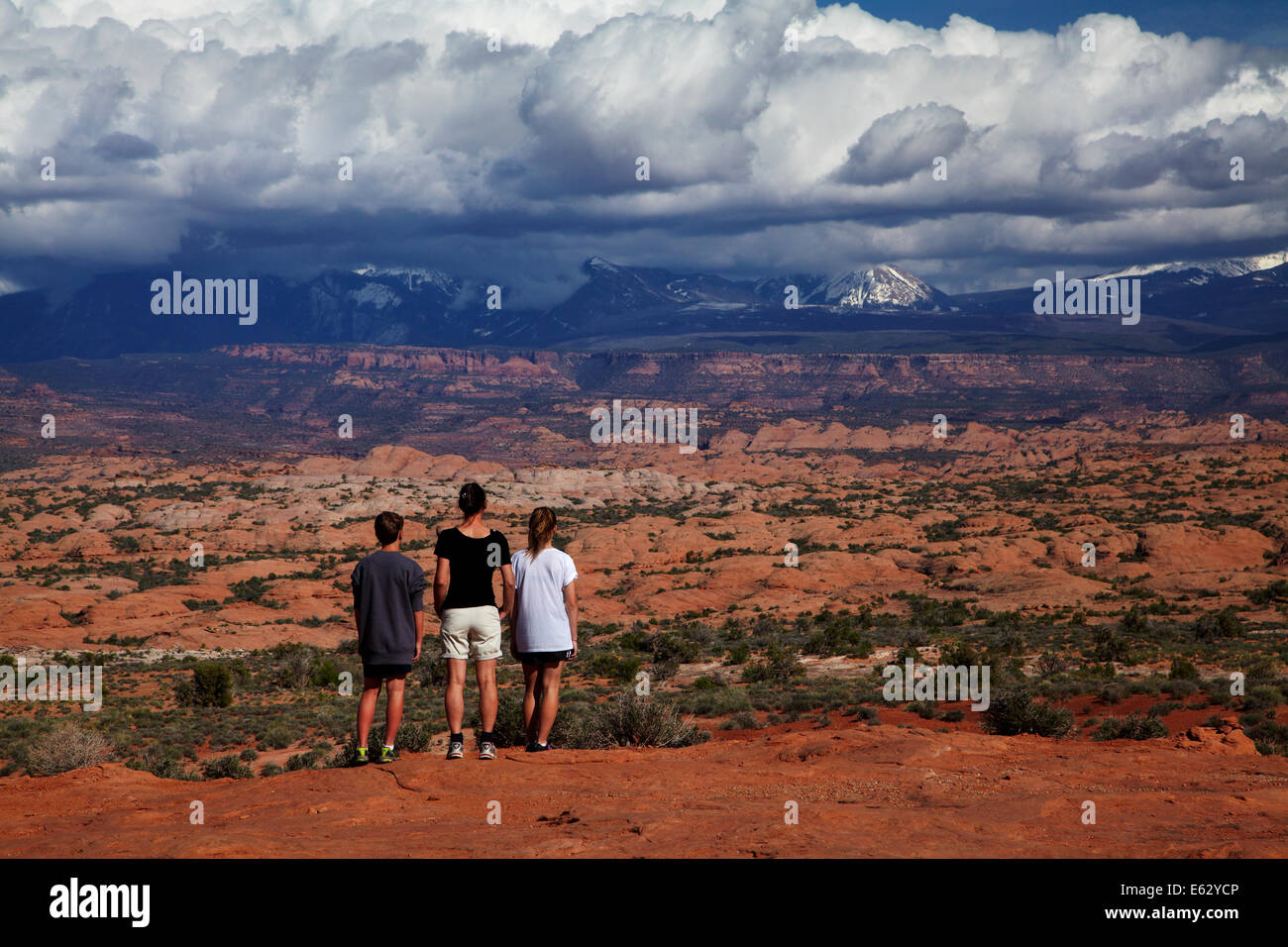 Tourists looking dark clouds over La Sal Mountains, from Arches ...