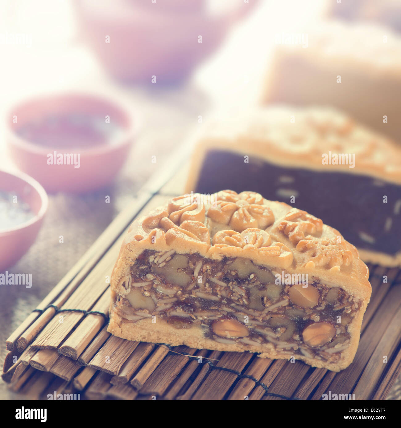 Traditional mooncakes on table setting with teacup. Retro vintage style ...