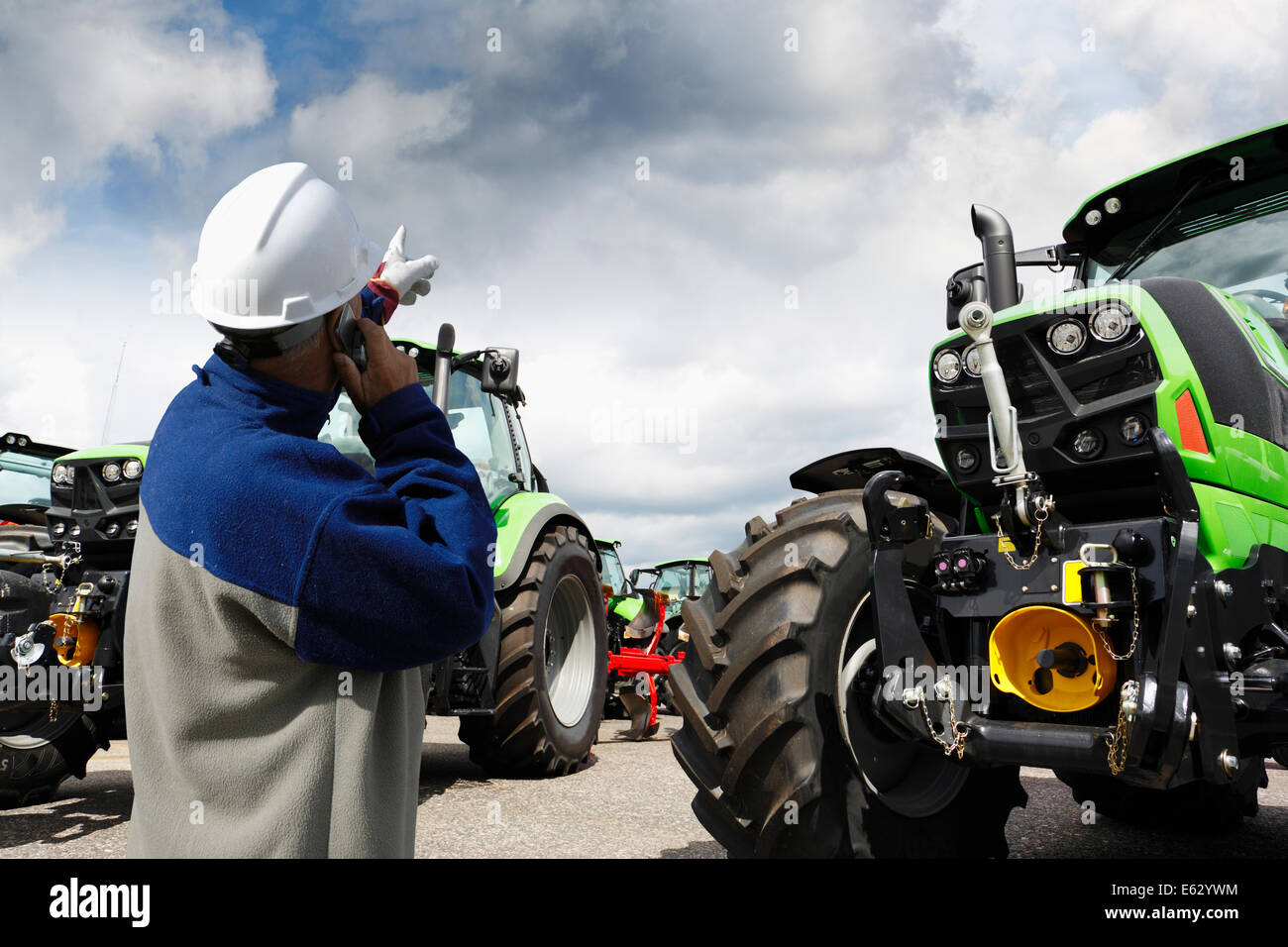 mechanic pointing at tractors line-up Stock Photo - Alamy
