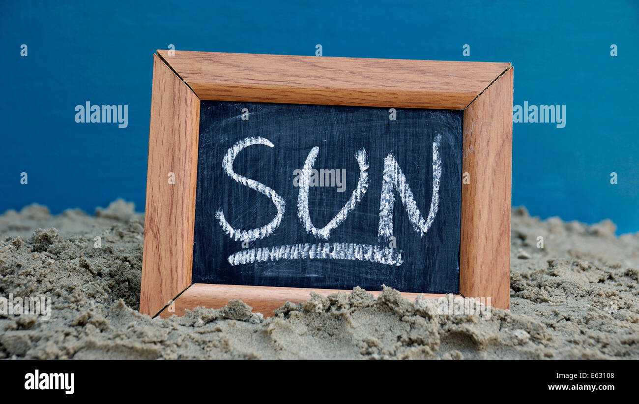 Sun written on a chalkboard at the beach Stock Photo - Alamy