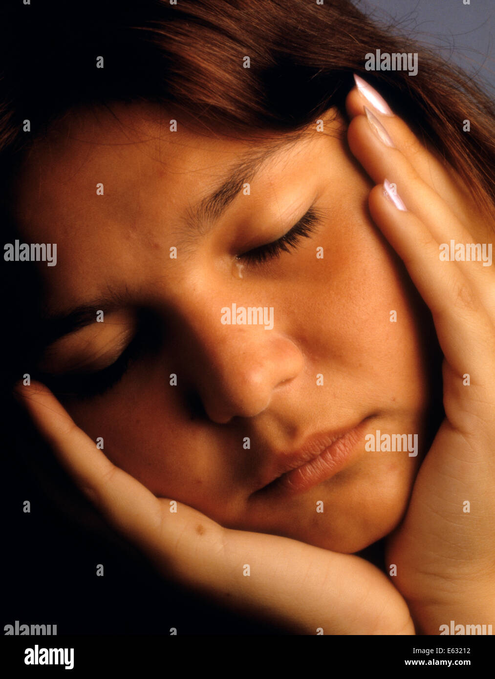 WOMAN HOLDING HER FACE NOT FEELING WELL SAD SINGLE TEAR ESCAPING LEFT ...