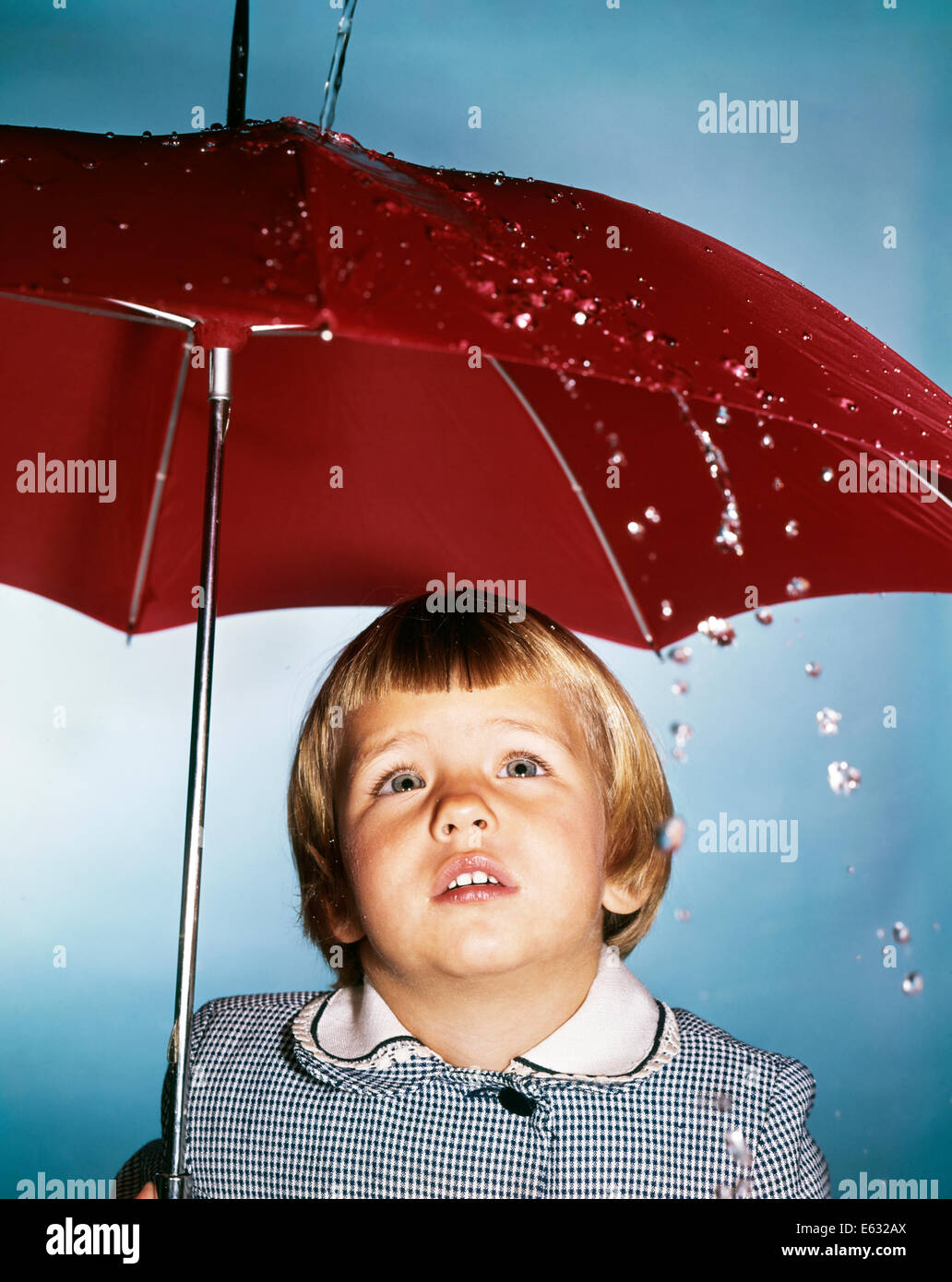 1960s LITTLE BLOND GIRL HOLDING RED UMBRELLA STANDING WATCHING RAIN ...
