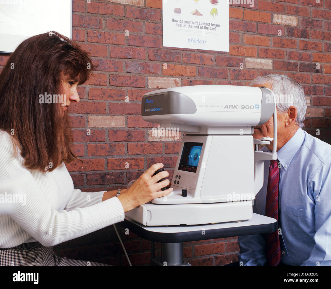 WOMAN OPTOMETRY TECHNICIAN GIVING EYE TEST TO OLDER MAN Stock Photo - Alamy