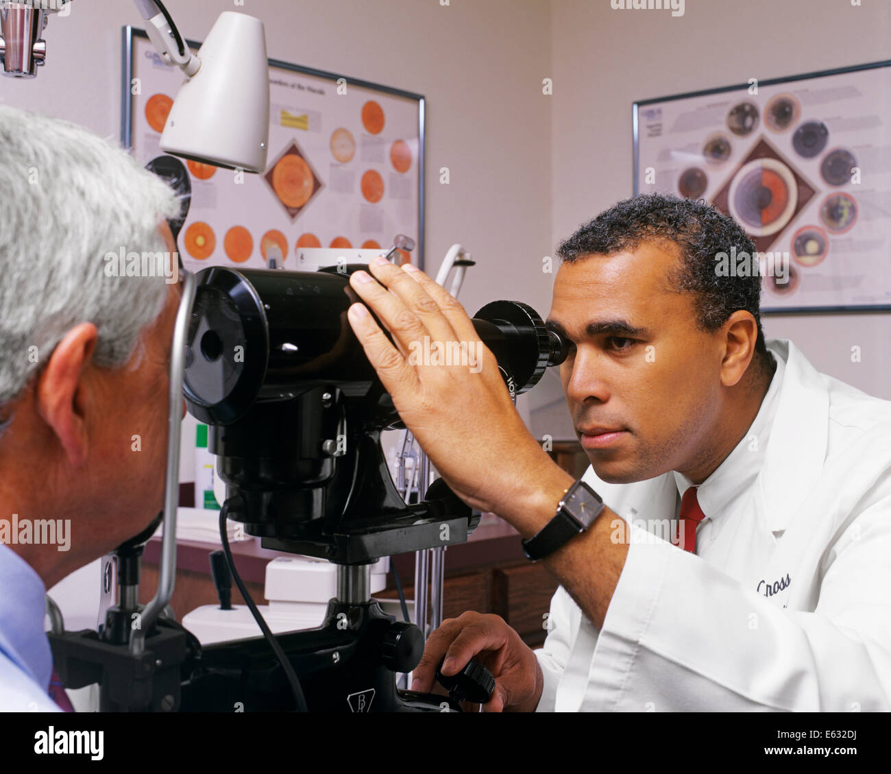 1990s AFRICAN AMERICAN OPTOMETRIST EXAMINING OLDER MAN'S EYES Stock ...