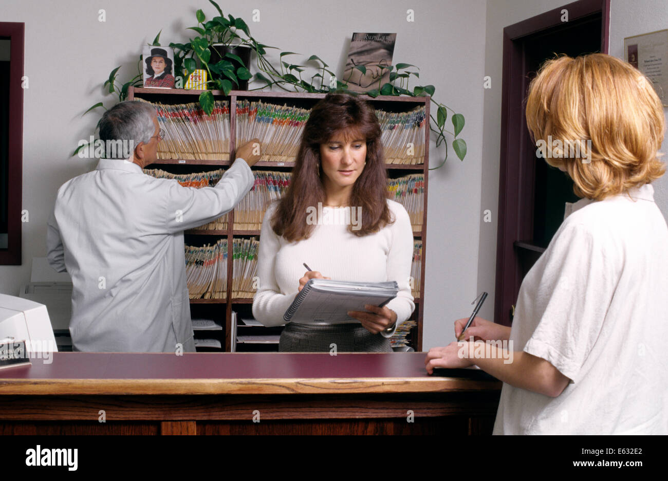 1990s 1990s RECEPTIONIST OPTOMETRIST AND PATIENT AT FRONT DESK Stock ...