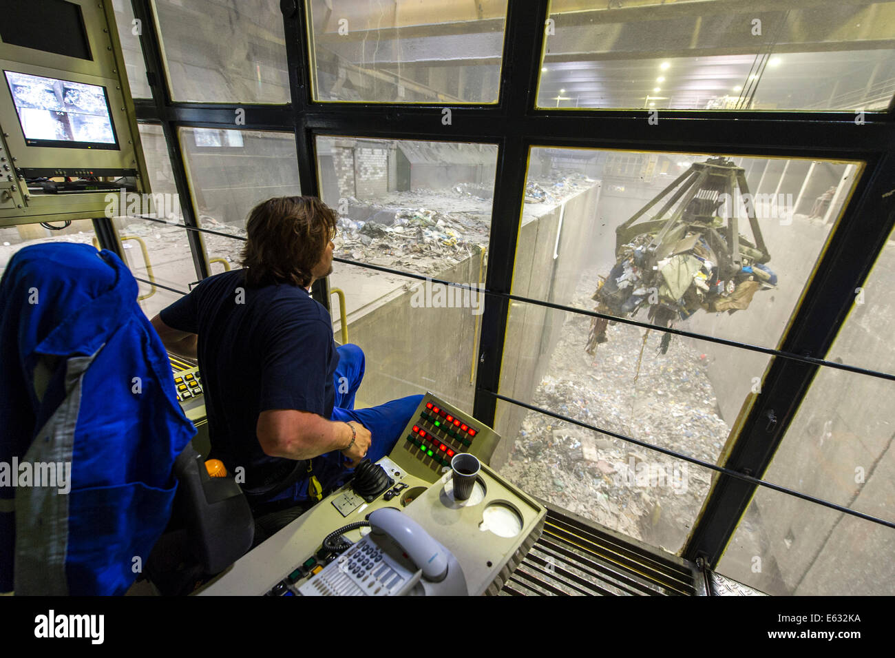 A crane operator is supervising the transport of waste to the ...