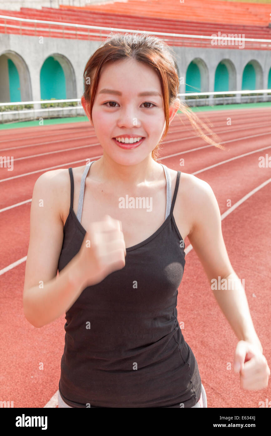 Asian female jogger on track at a stadium jogging in race Stock Photo ...