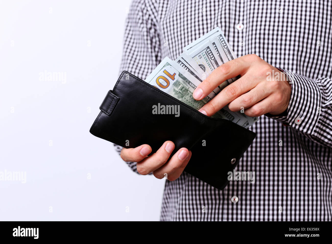 Hand pulling 100 dollars banknotes from wallet Stock Photo - Alamy