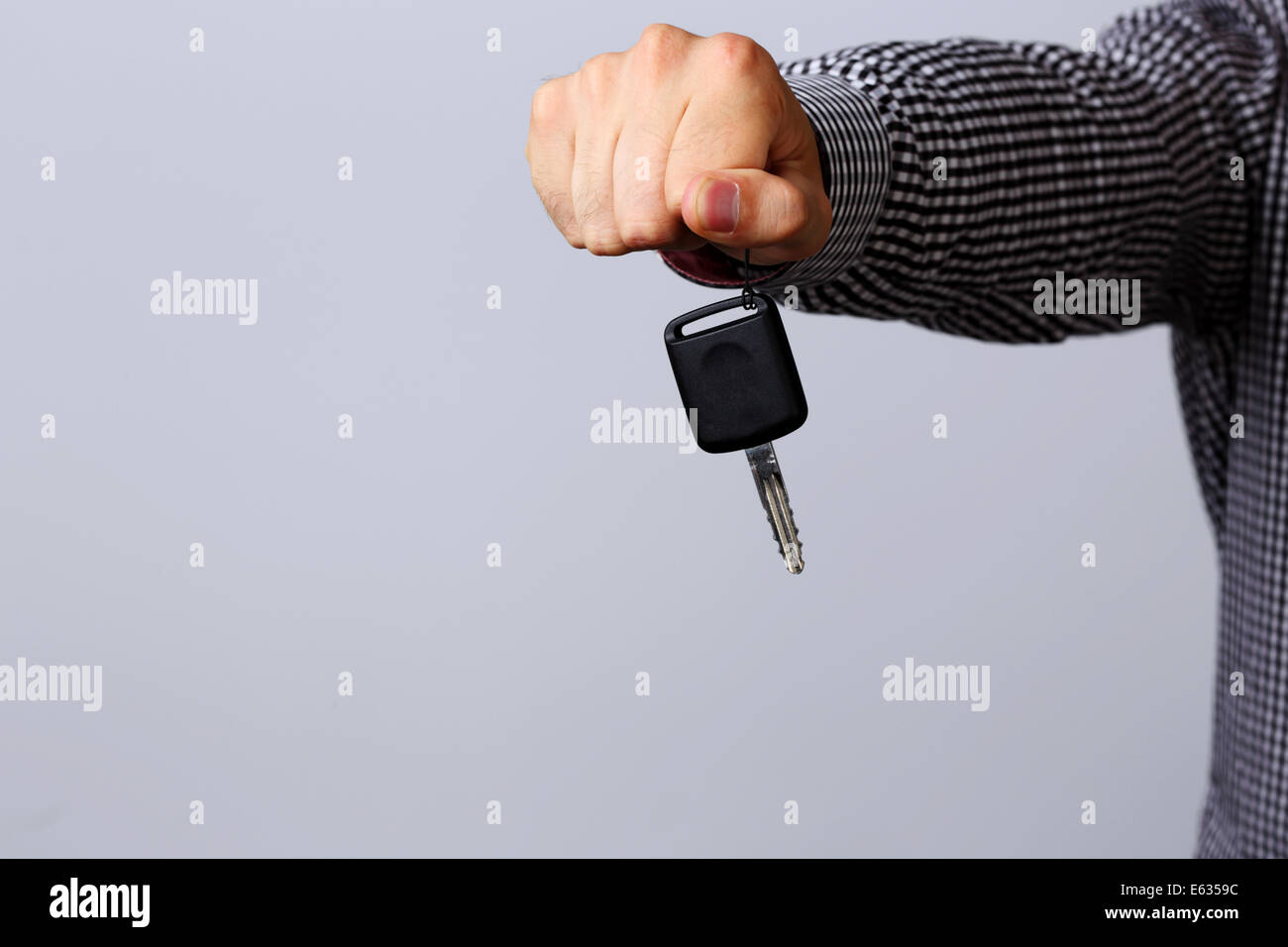 Hand holding car keys isolated on gray background Stock Photo - Alamy