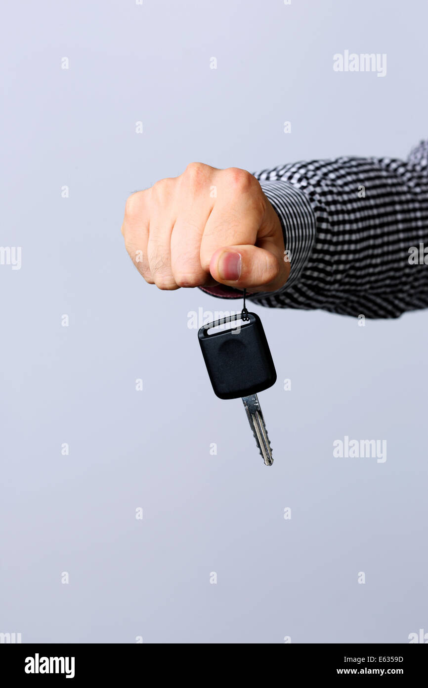 Hand holding car keys isolated on gray background Stock Photo - Alamy