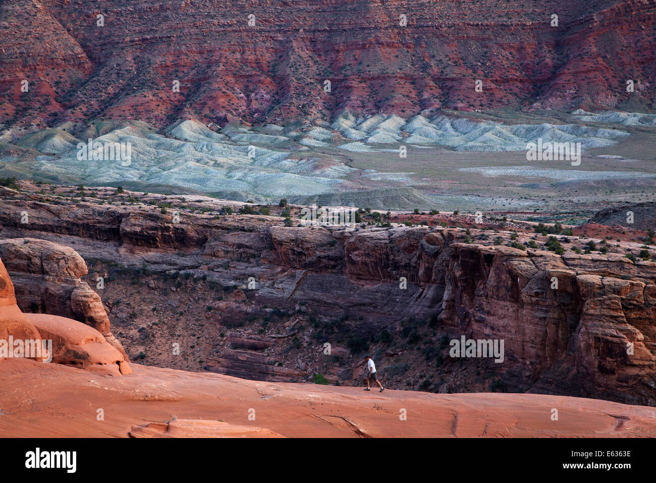 Hiker on cliff edge near Delicate Arch, Arches National Park, near Moab ...