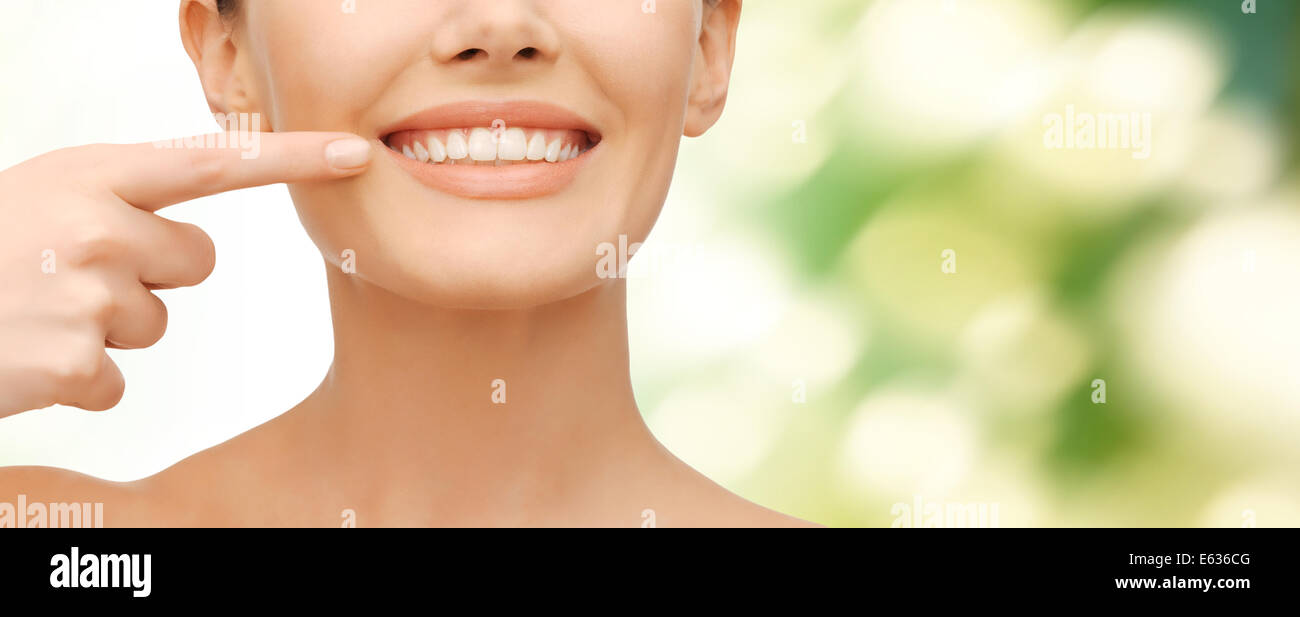 beautiful woman pointing to teeth Stock Photo - Alamy