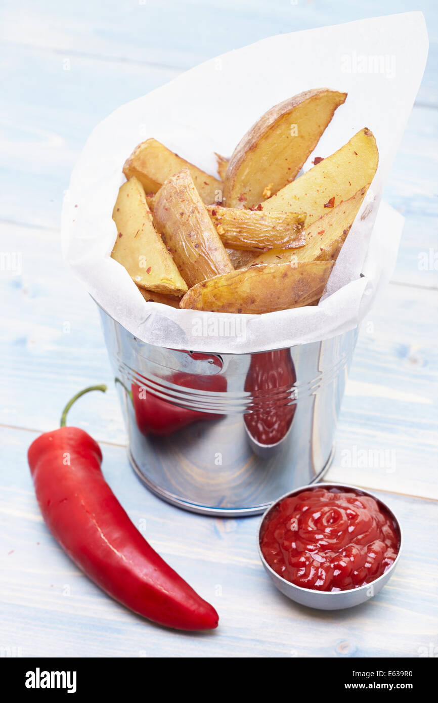 Homemade Fries in a small metal bucket with chili pepper and ketchup ...