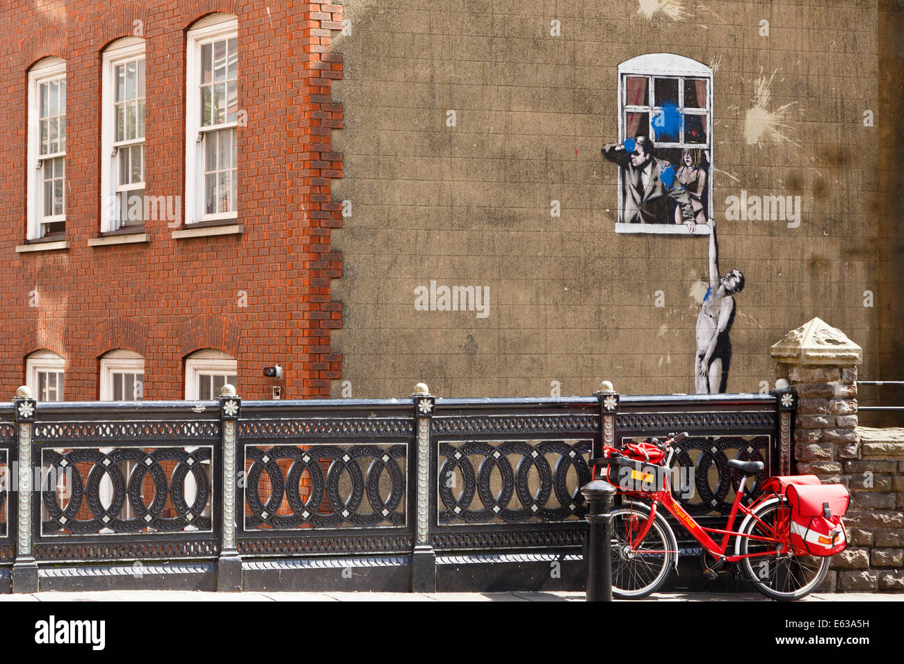 Banksy graffiti of man hanging from window. Humorous juxtaposition of ...