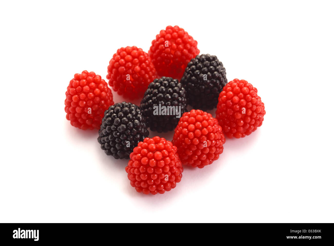 Red and black berry candy on white background Stock Photo - Alamy