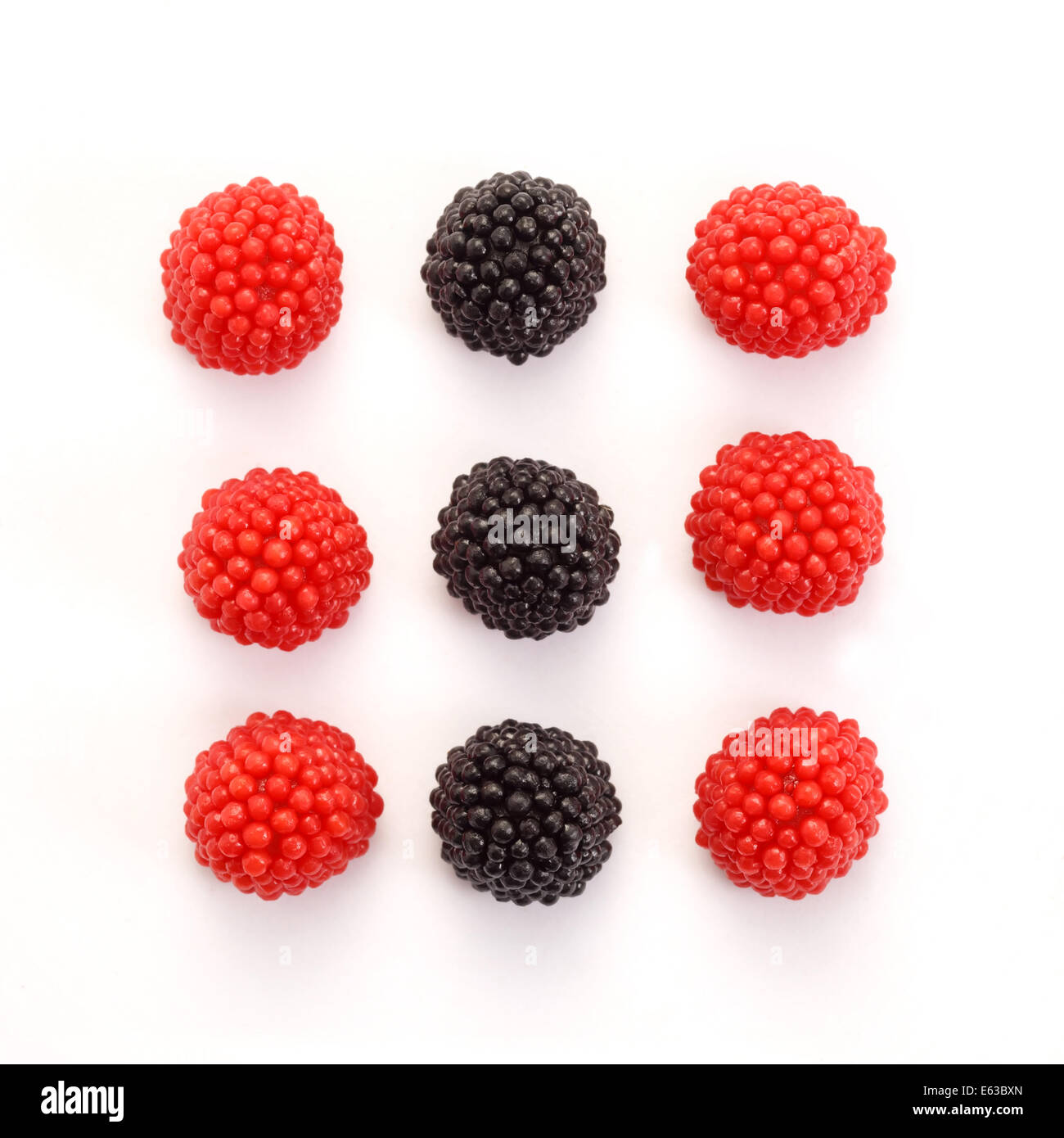 Red and black berry candy on white background Stock Photo - Alamy