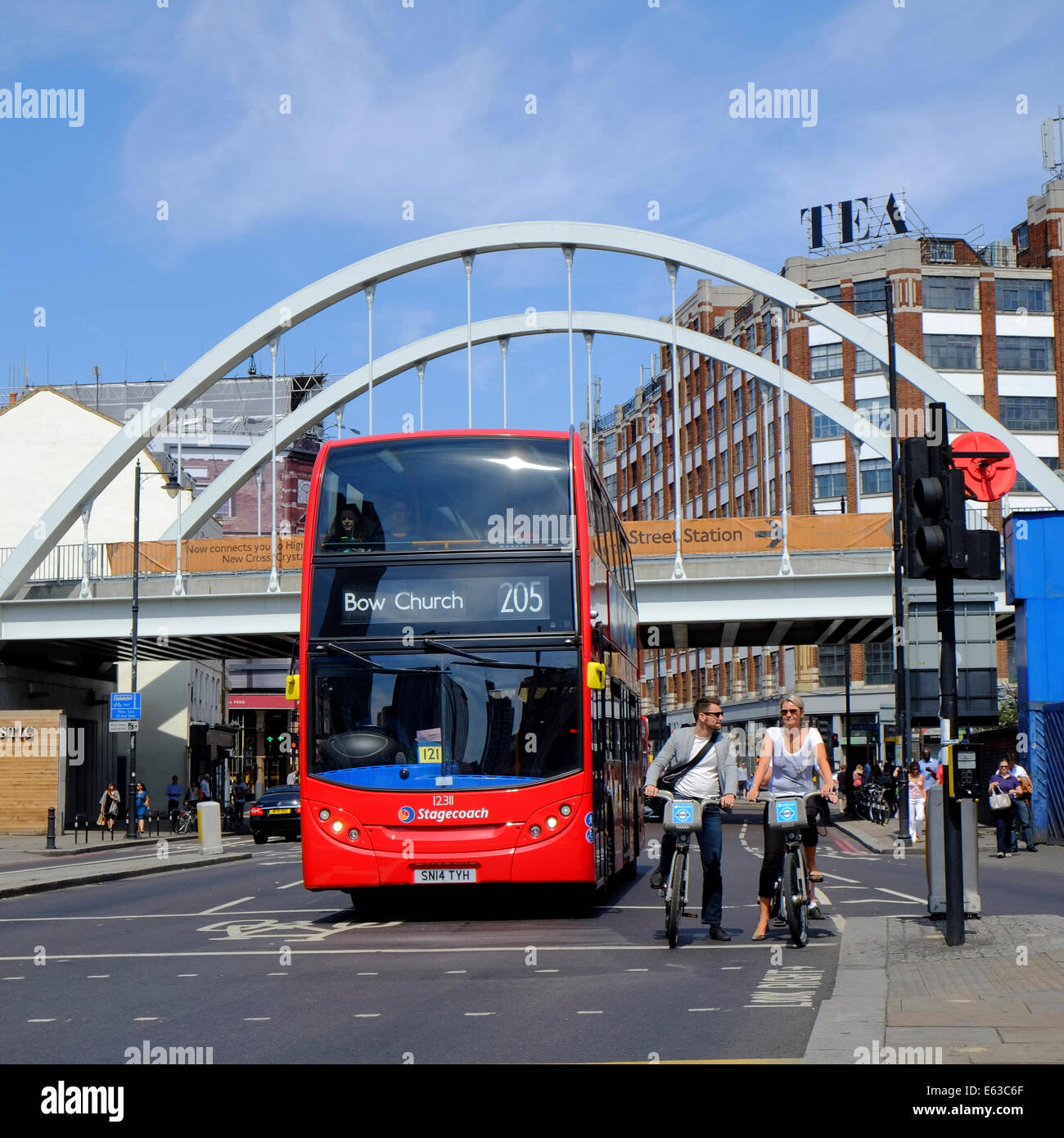 red London bus and cyclists on Boris bikes waiting at traffic lights on ...