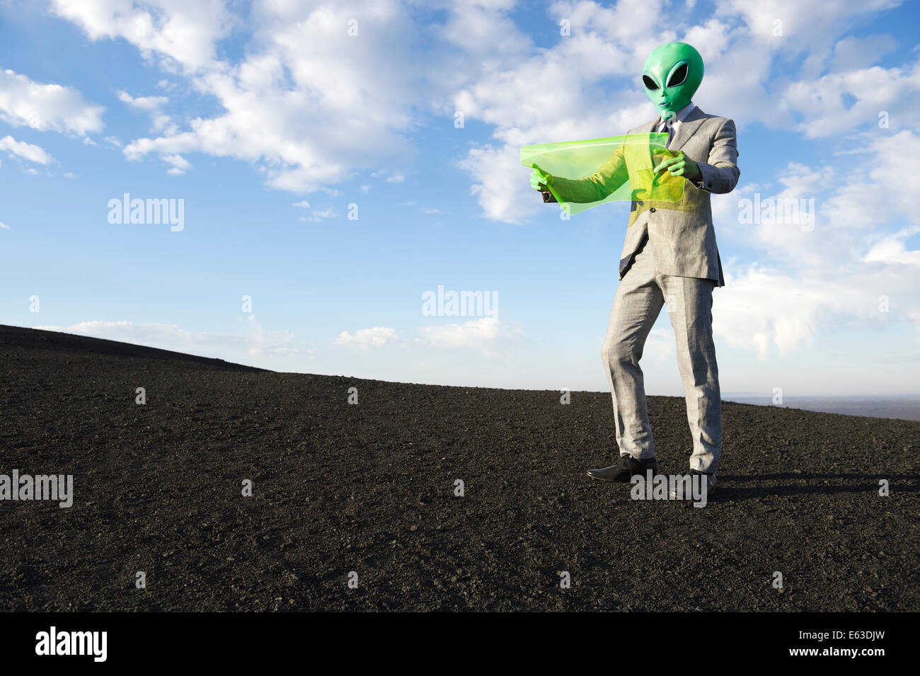 Explorer alien businessman in lunar landscape reading electronic map on ...