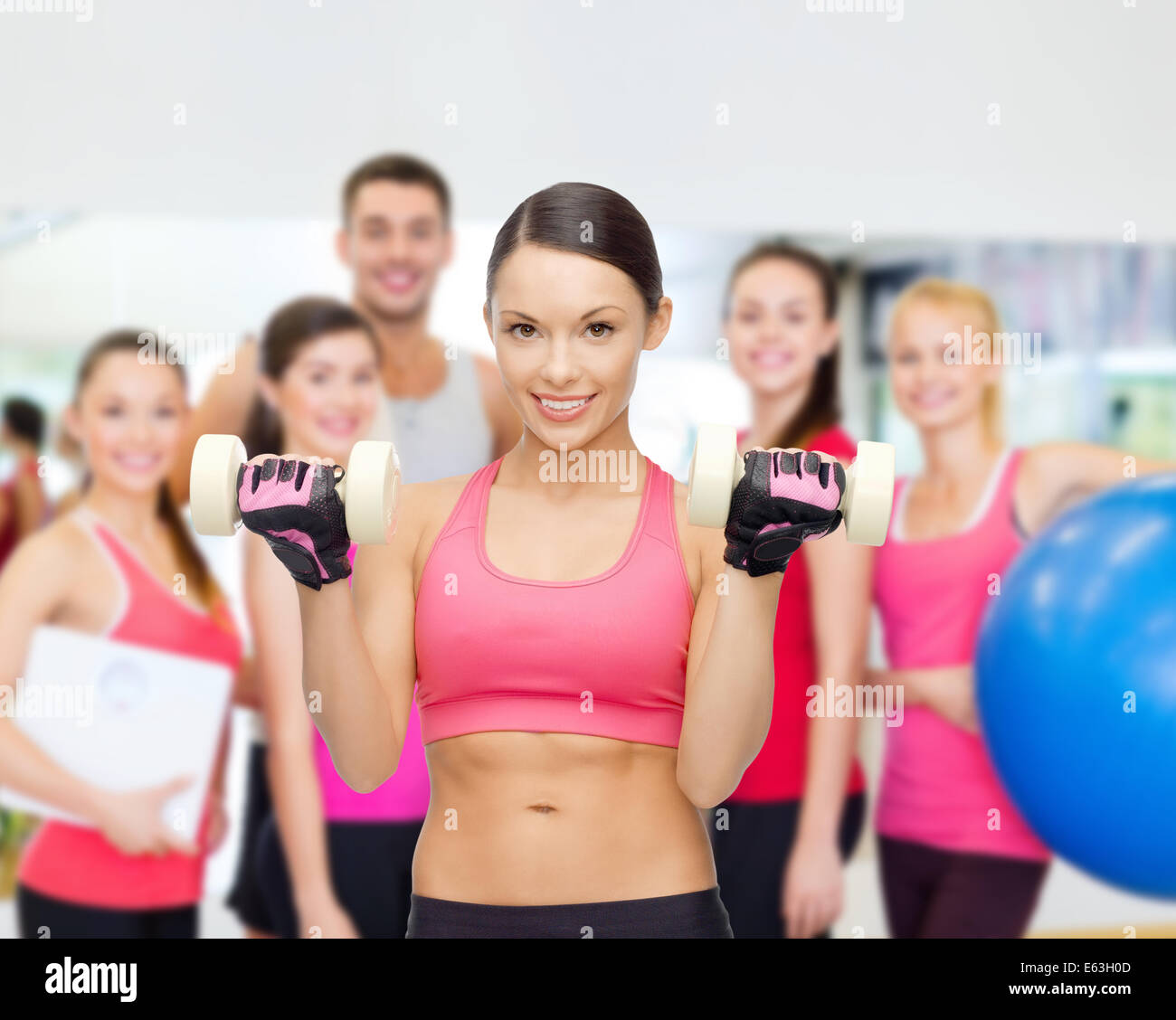 personal trainer with group in gym Stock Photo - Alamy
