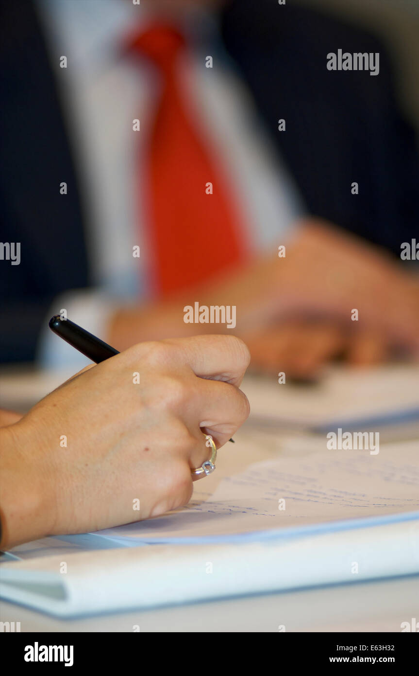 Female hand writing and taking notes in an office during a business ...
