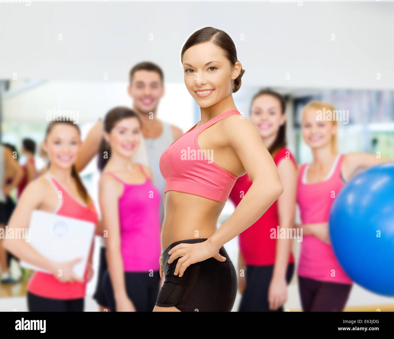 personal trainer with group in gym Stock Photo - Alamy
