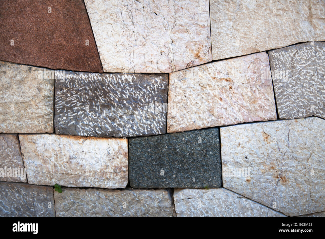 Stone wall with add shaped blocks and various colors and textures of ...