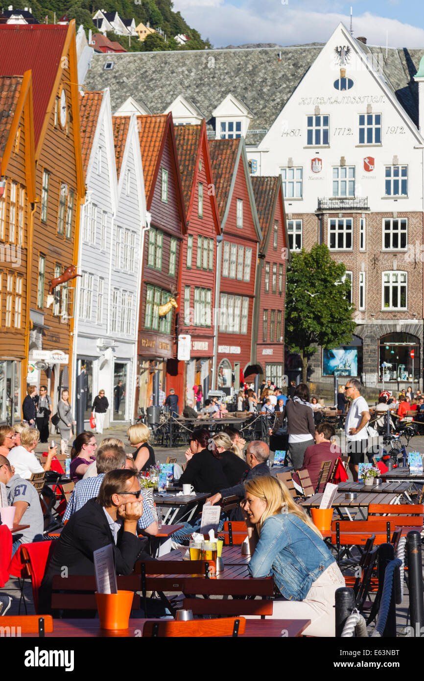 People sitting at outdoor terraces of the pubs at Bryggen wharf, Bergen ...