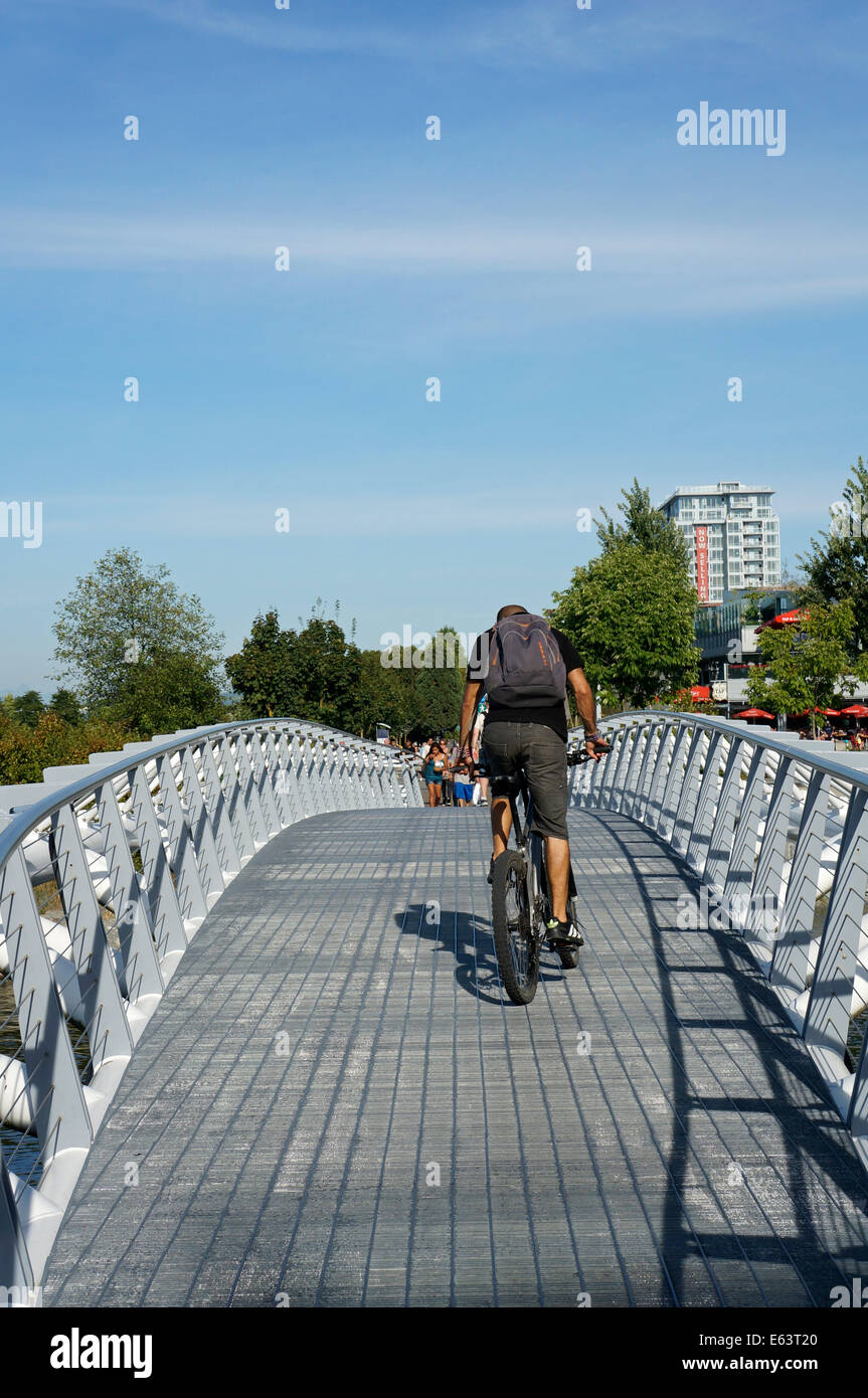 Cyclist crossing the Canoe Bridge False Creek Village, Vancouver, BC ...