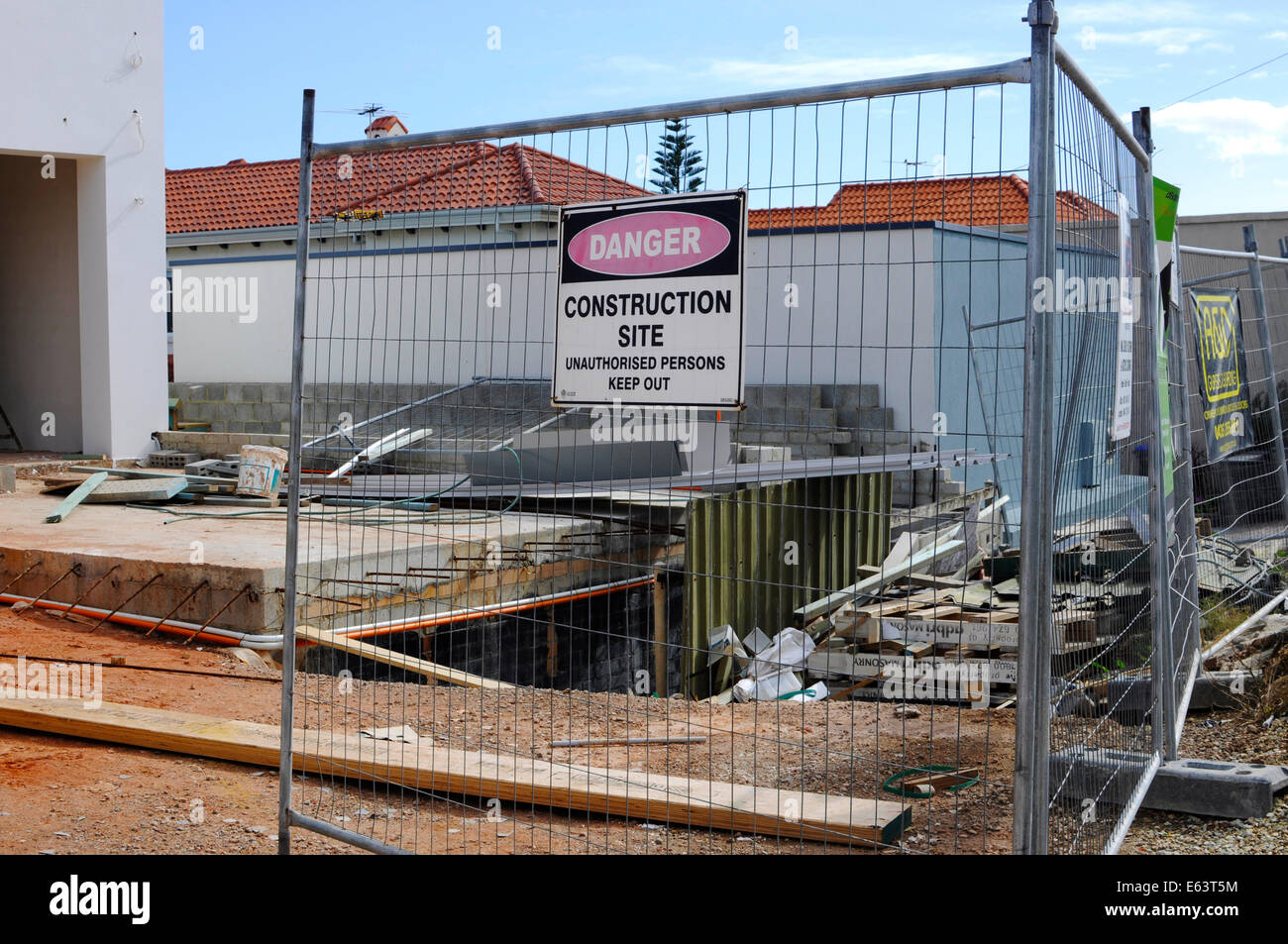 Small construction demolition site with danger warning sign on fence ...