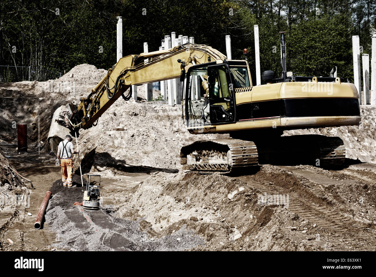 giant bulldozer and workers in excavating action Stock Photo - Alamy