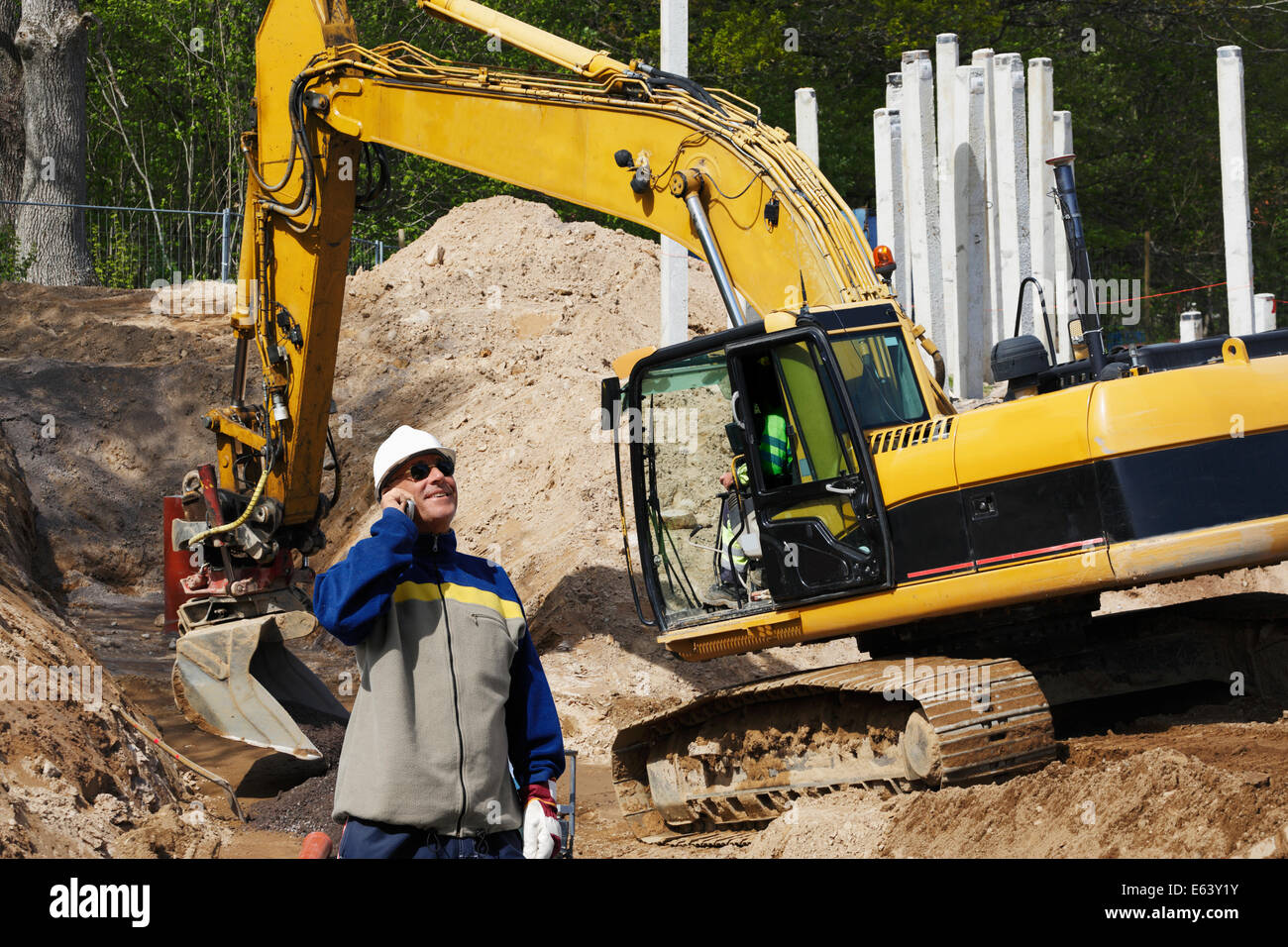 bulldozer, digger and site worker in action Stock Photo - Alamy