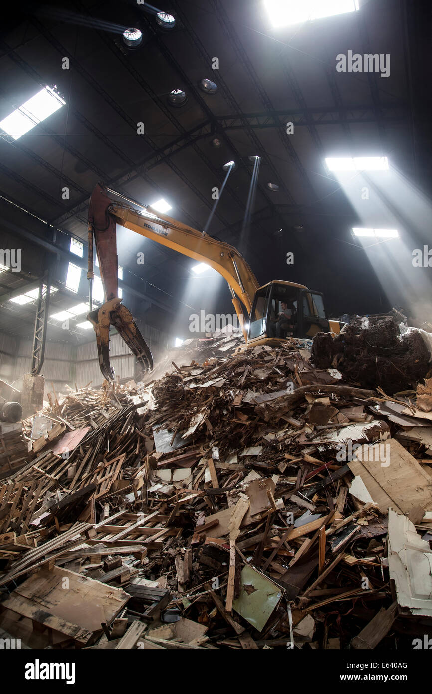 Heavy duty machinery used for dealing with a pile of waste timber in a ...