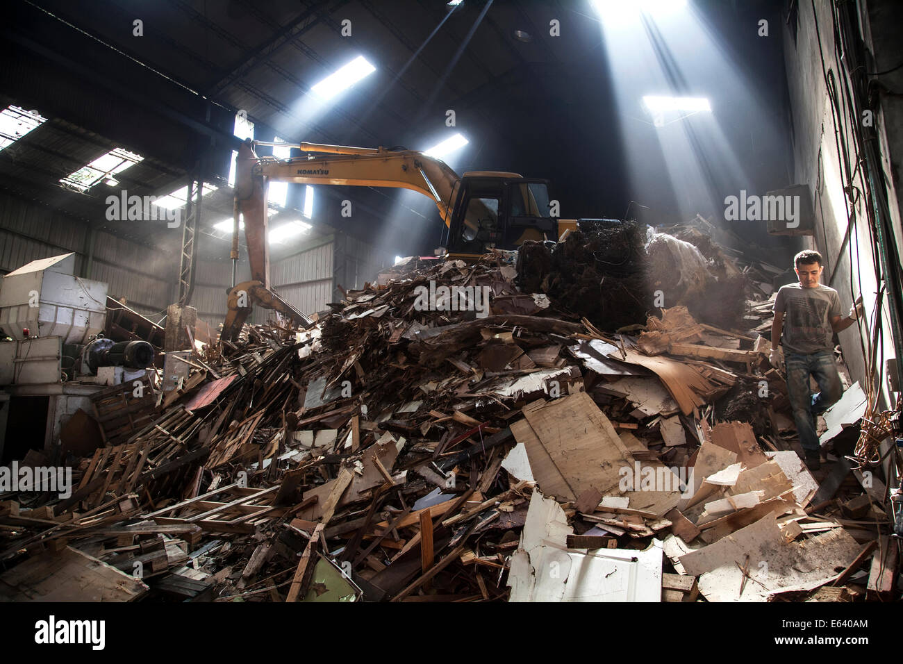 Heavy duty machinery used for dealing with a pile of waste timber in a ...