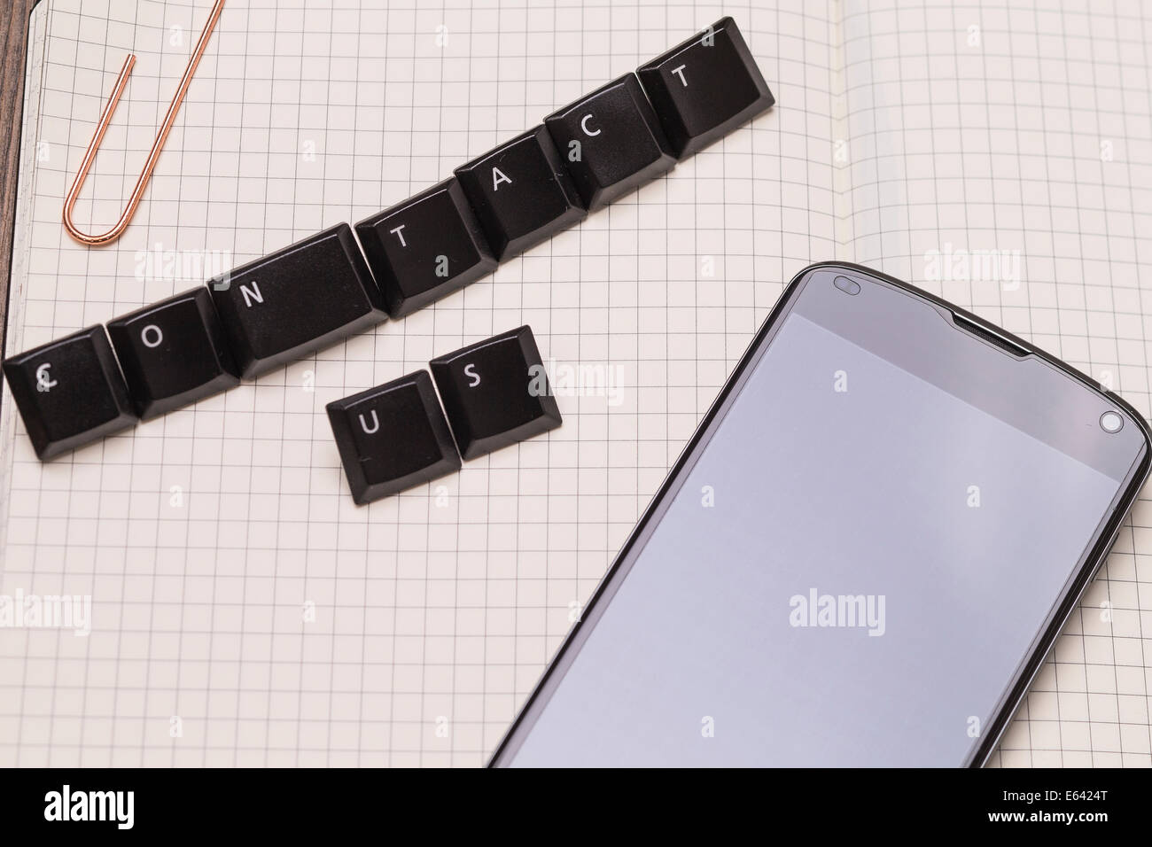 Image shows an empty opened notebook with mobile and set of letters ...