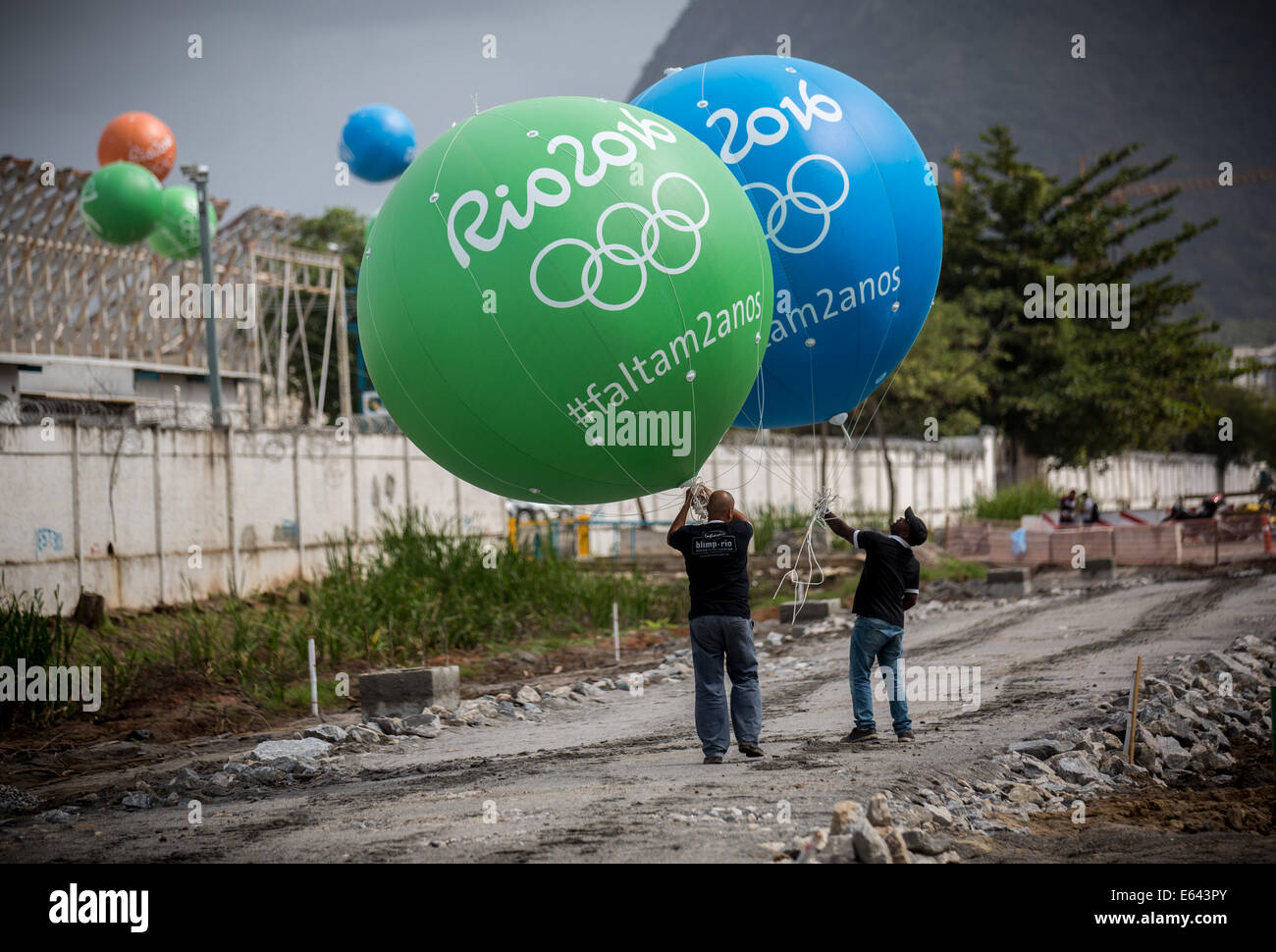 Workers with large balloons, featuring the writing 'Rio 2016', walk ...