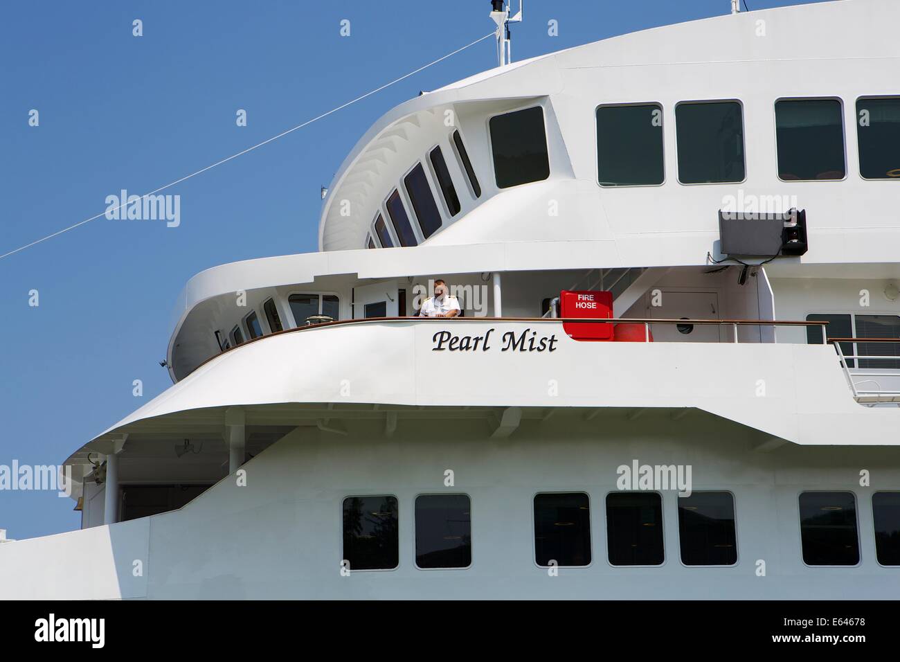 A crew member watches the side of the Pearl Mist as it navigates the ...