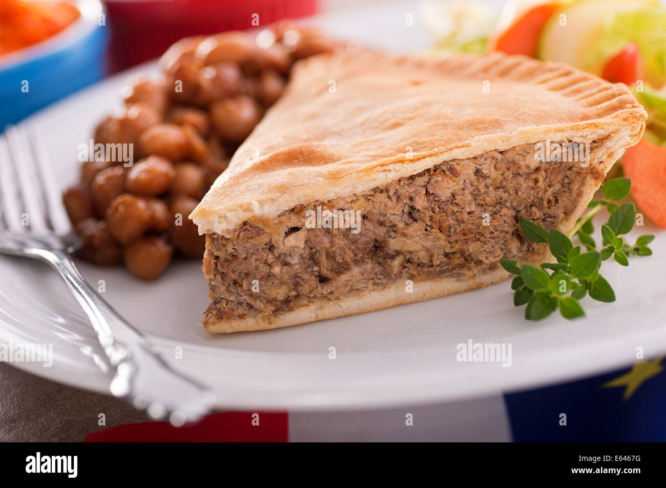 A slice of freshly baked Acadian meat pie with baked beans and garden ...