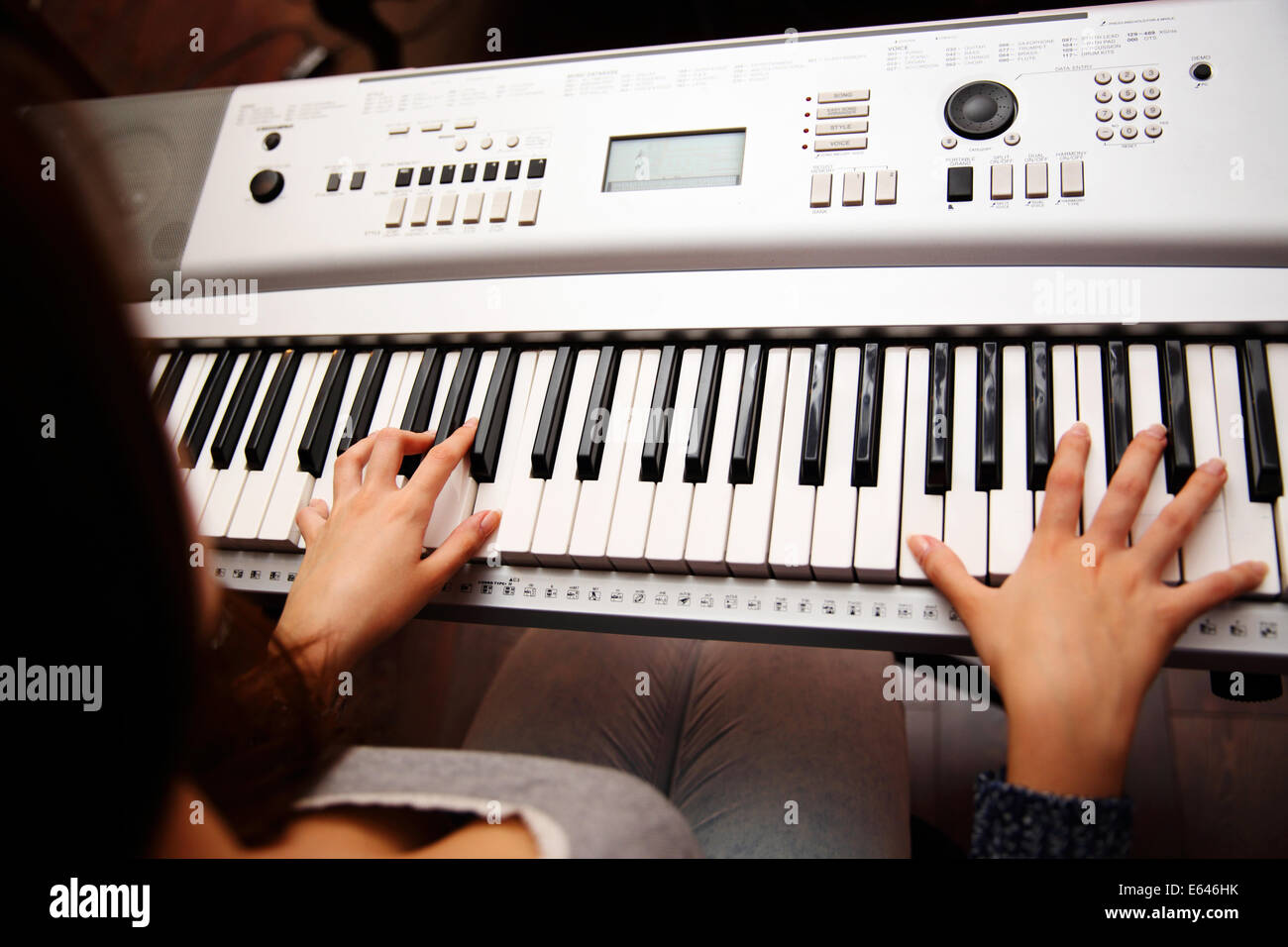 Female piano player, view from the top, body and buttons of the piano ...